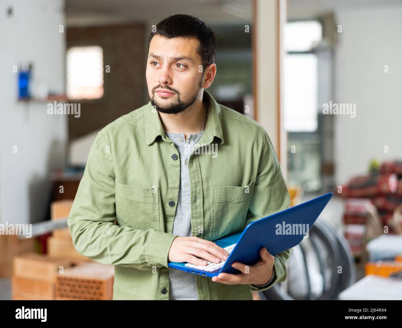 Civil engineer monitors the process of capital repairs on a laptop ...
