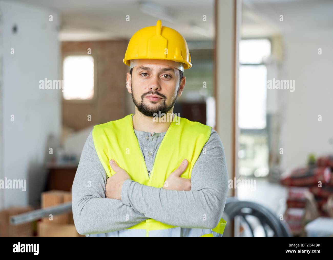 Confident young architect standing in building under construction Stock ...
