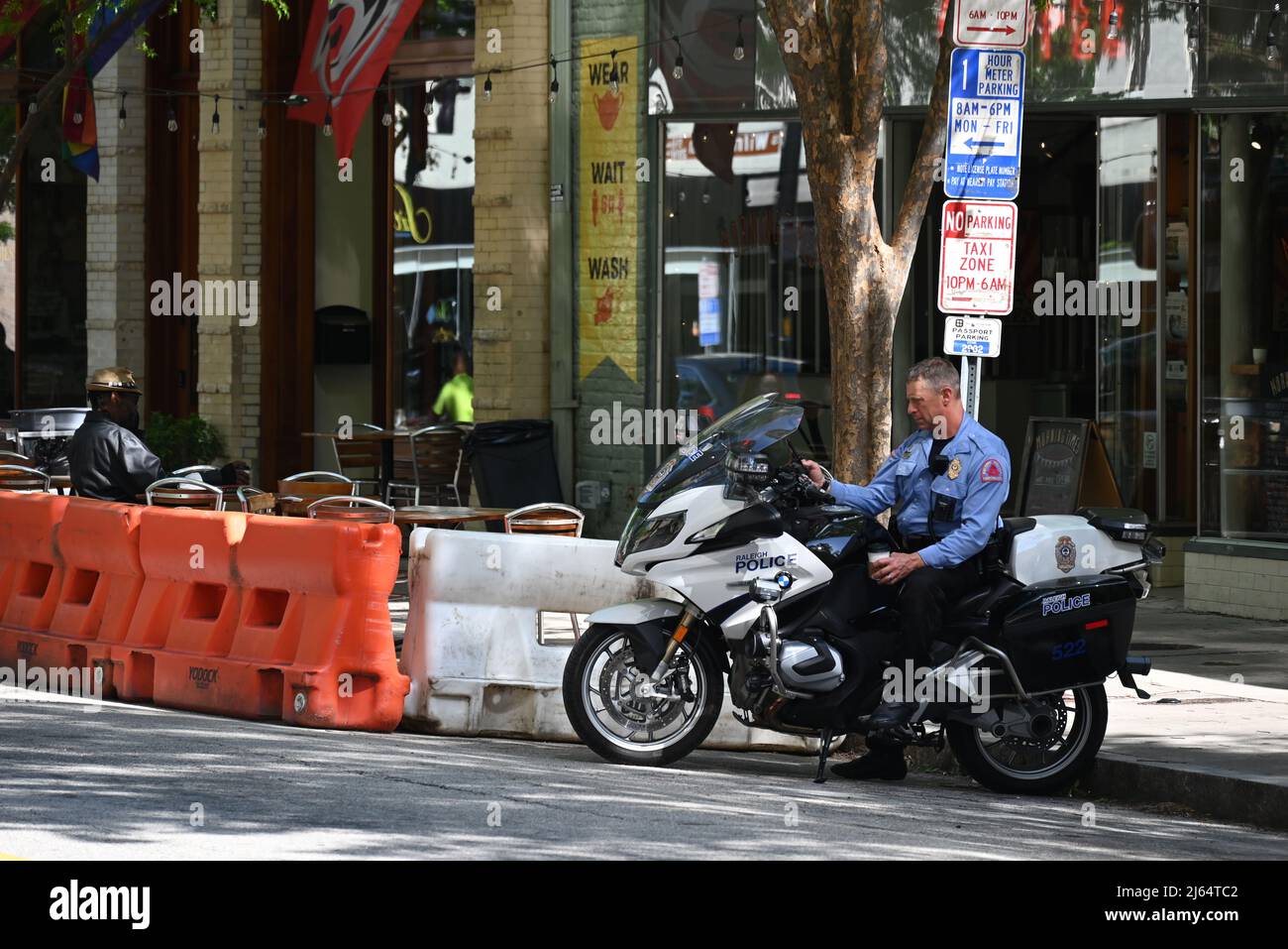A police officer takes a coffee break and checks messages in downtown ...