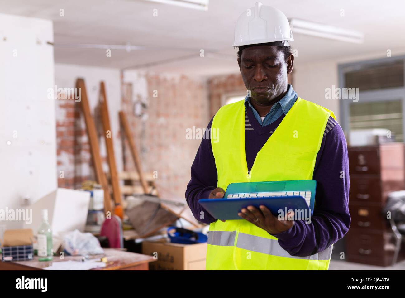 African american supervisor with laptop inspecting construction site ...