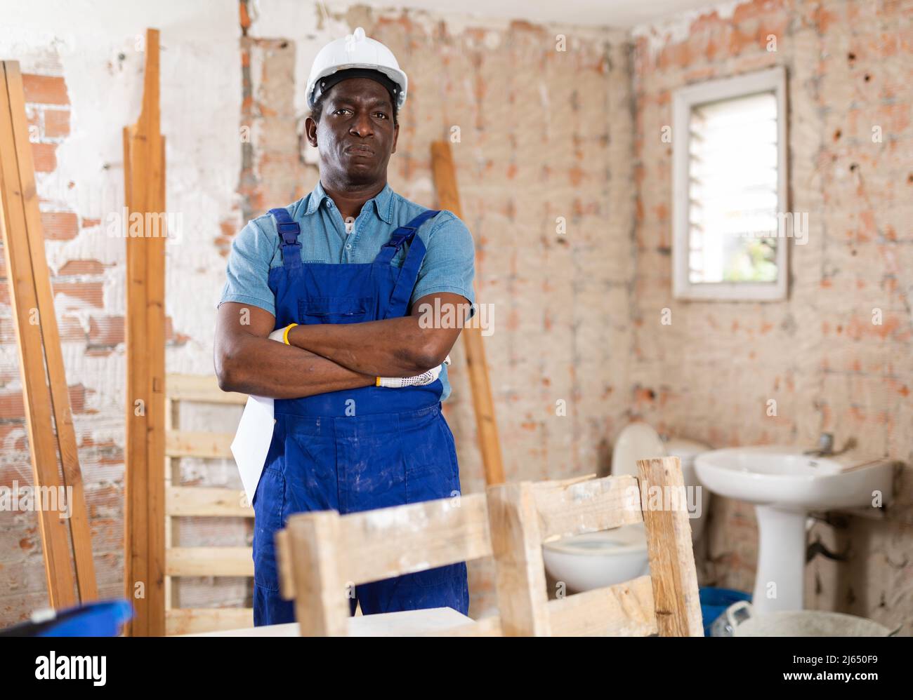 Confident african american construction worker in house under ...