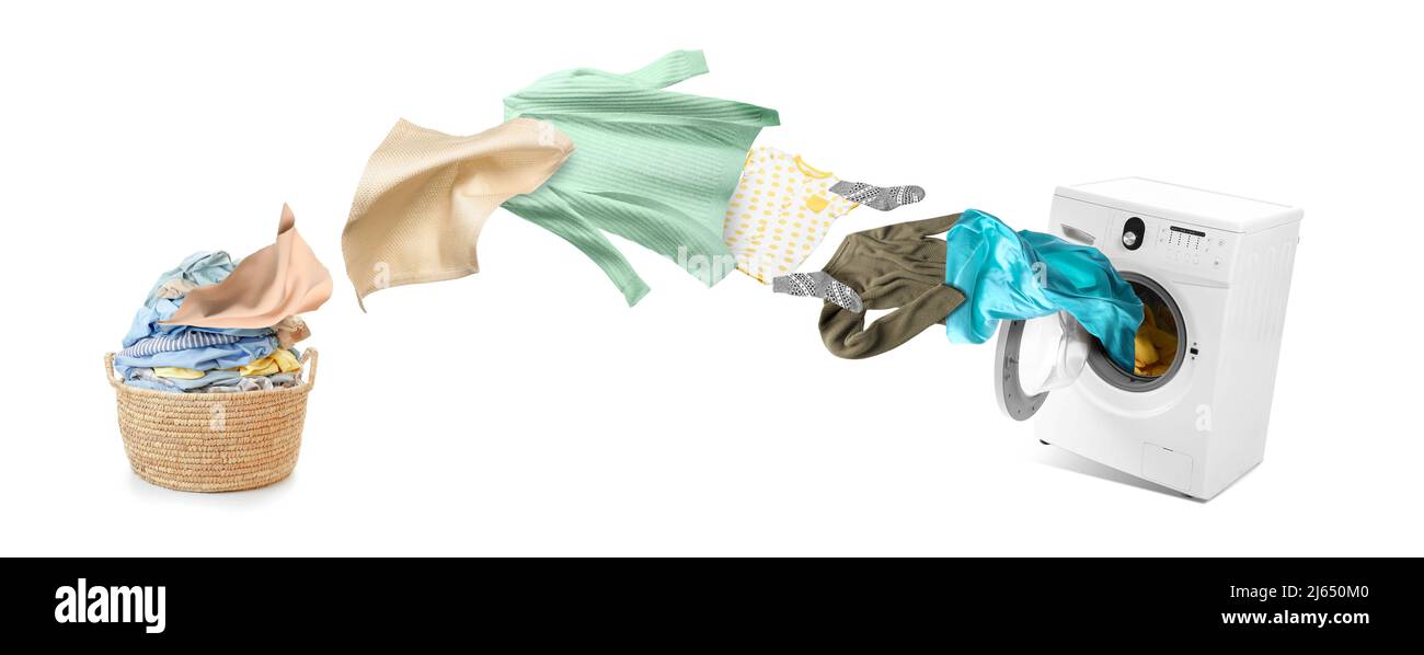 Dirty clothes getting from wicker basket into washing machine on white ...