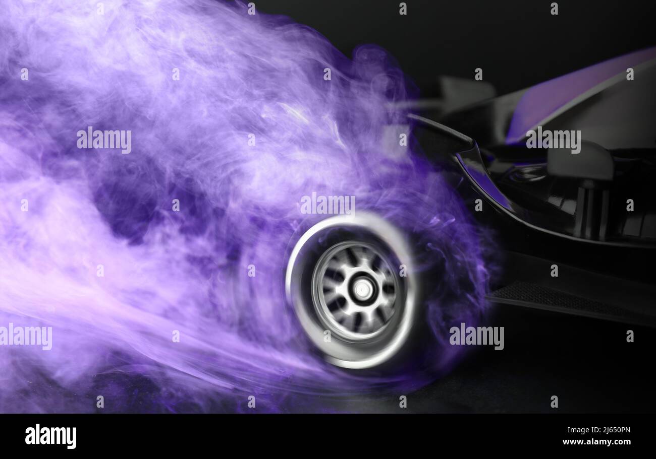 Modern racing car with violet smoke from under wheels on black ...