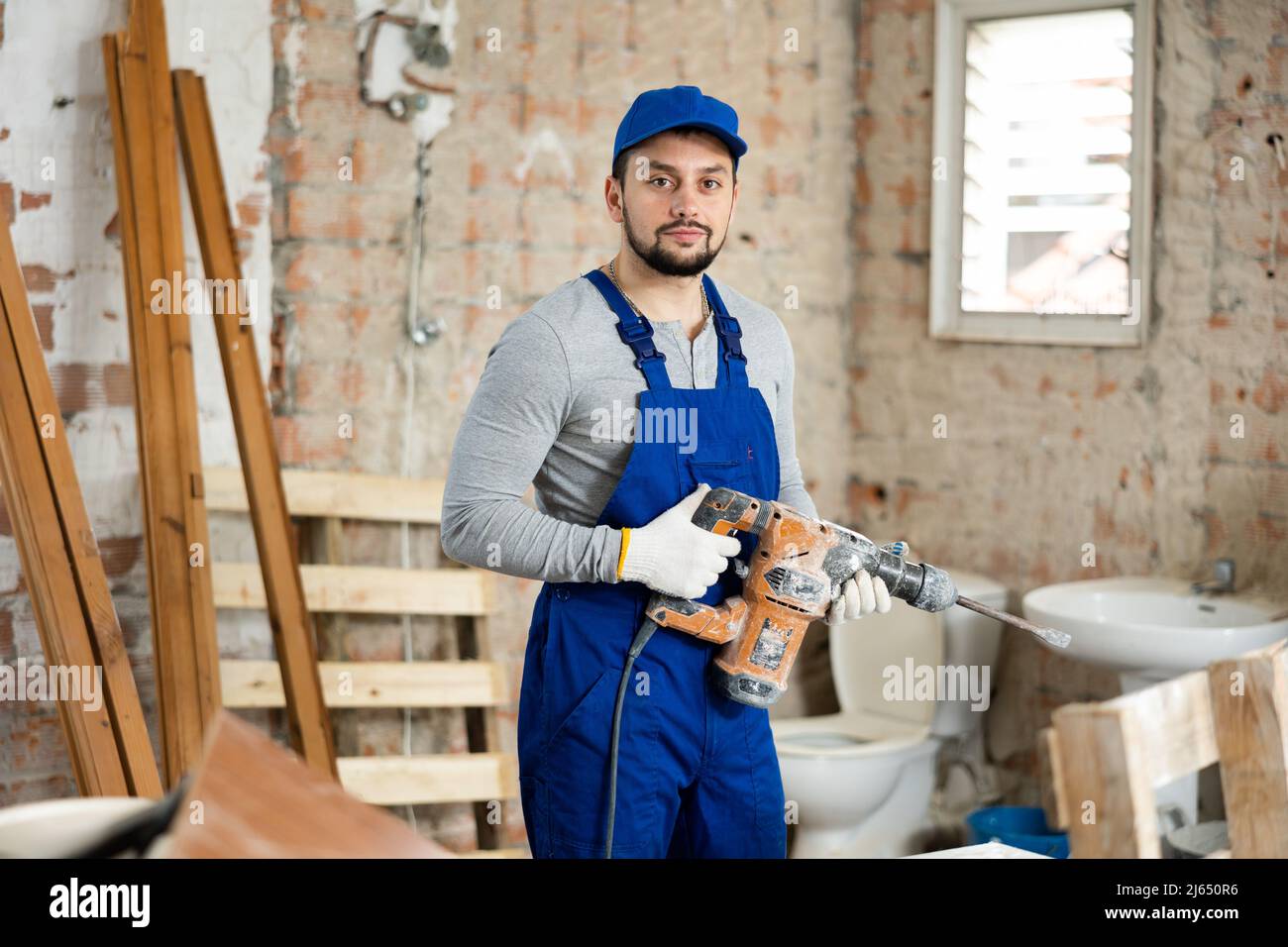 Confident builder posing on indoor construction site Stock Photo - Alamy