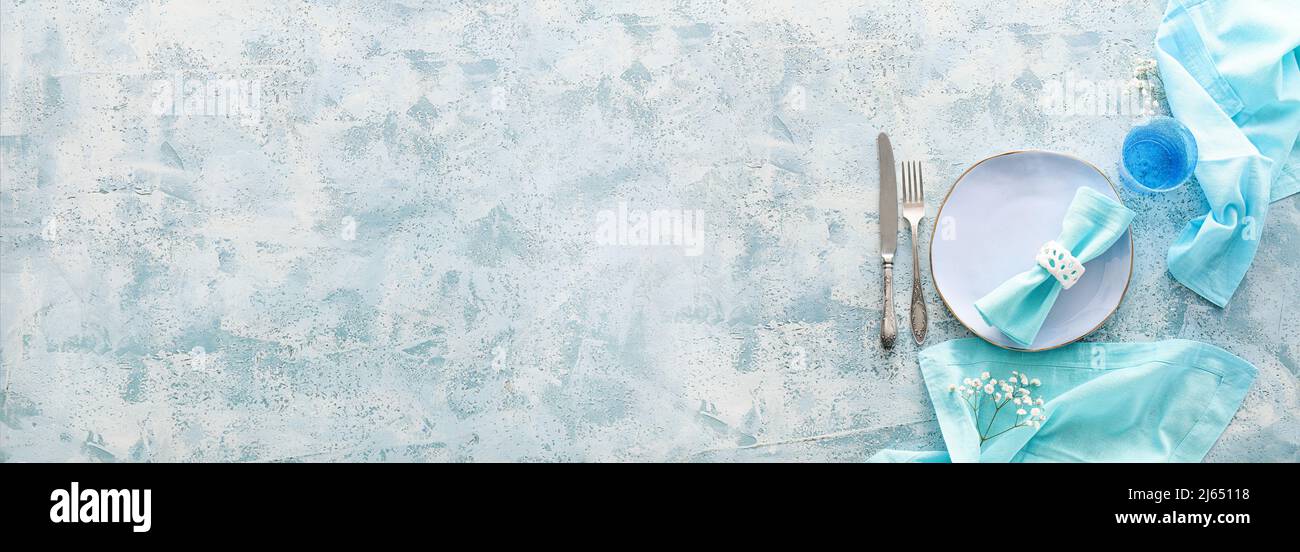 Beautiful table setting in light blue colors on grunge background with ...