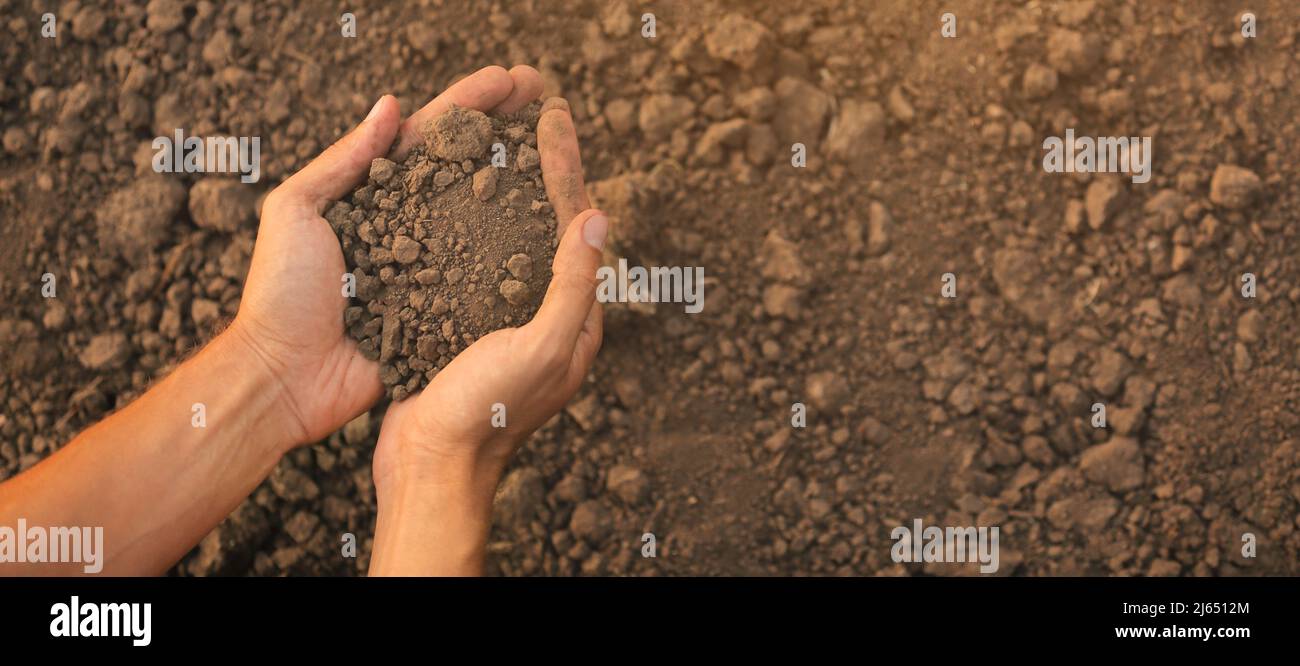 Hands of farmer with heap of soil in field. Banner for design Stock ...