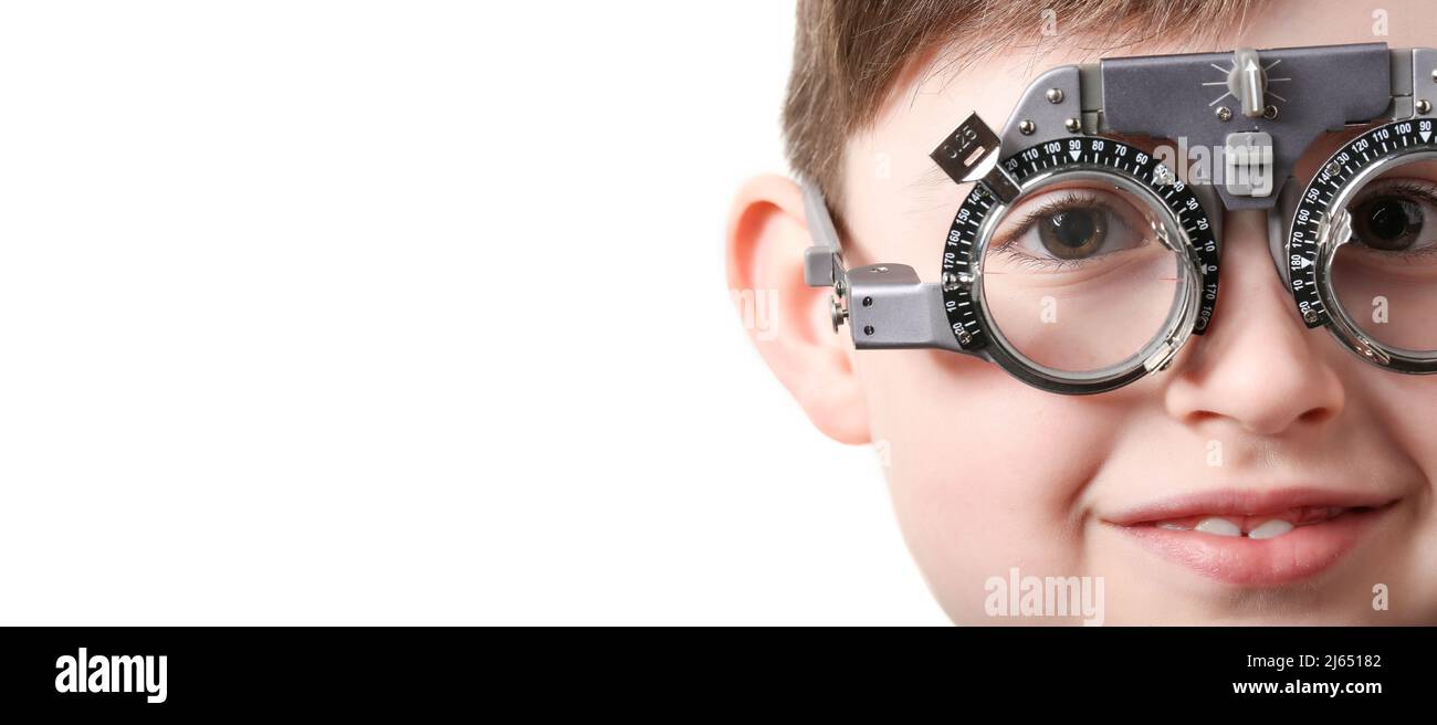 Little boy with trial frame undergoing eye test on white background ...
