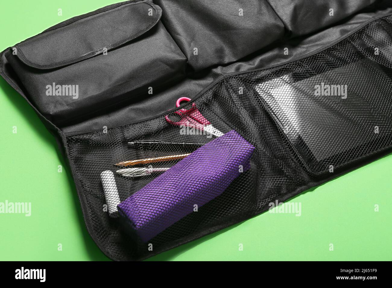 Travel organizer with stationery and tablet computer on green ...