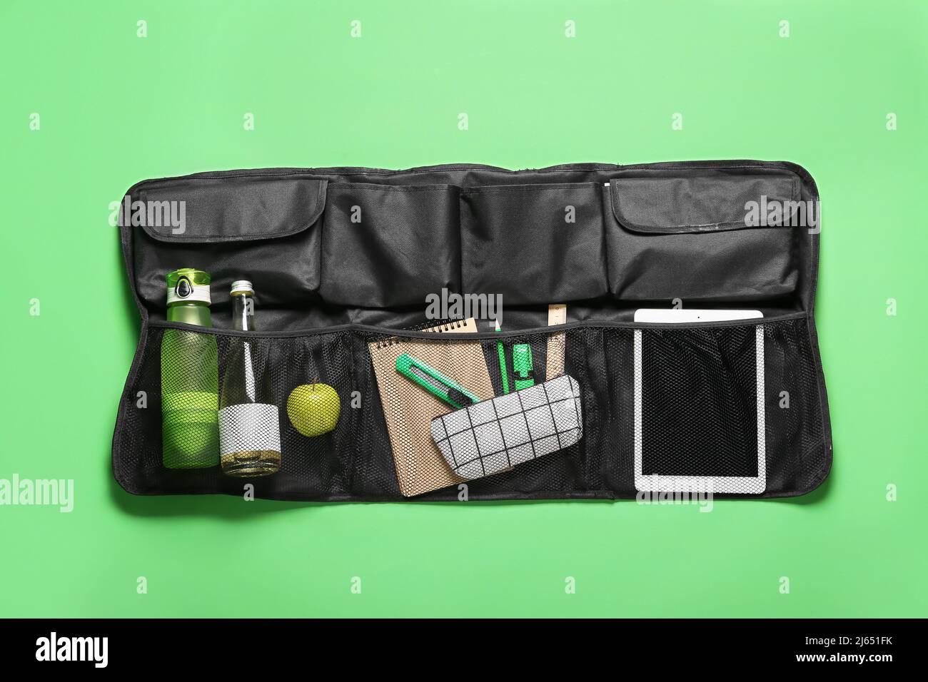 Travel organizer with stationery, tablet computer, bottles of drink and ...