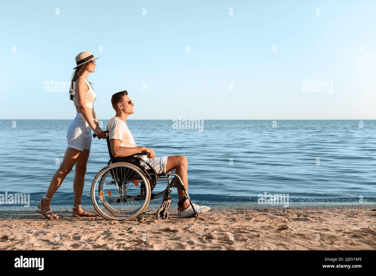 Young man with physical disability and his girlfriend at sea resort ...