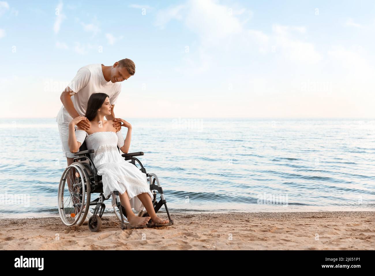 Young woman with physical disability and her boyfriend at sea resort ...