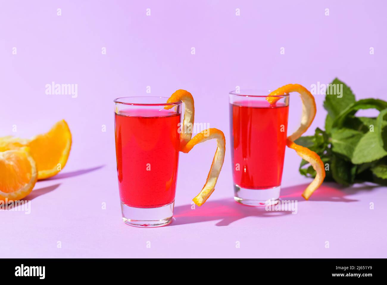 Shot cocktails and oranges on color background Stock Photo - Alamy