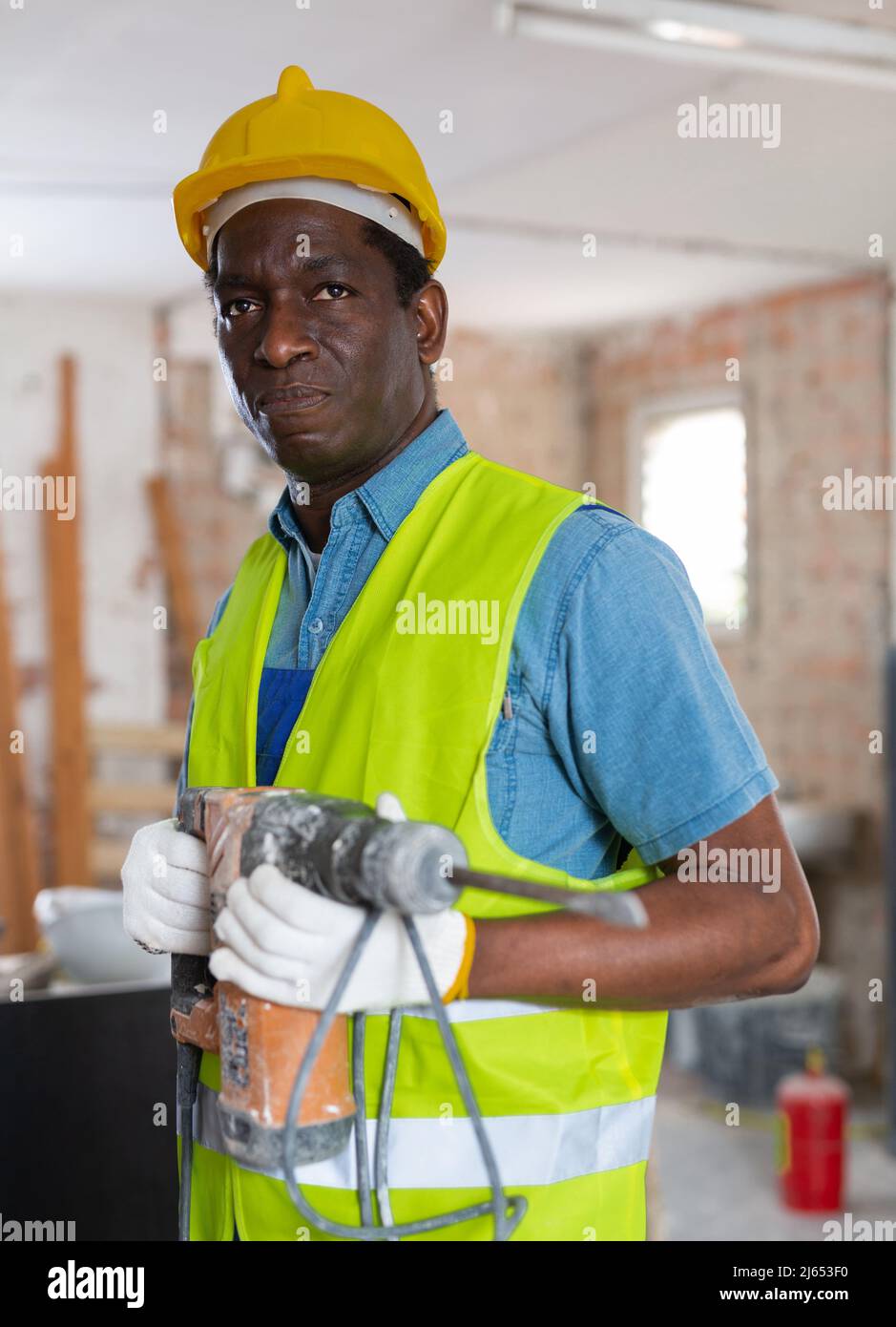 Portrait of man builder standing in construction site Stock Photo - Alamy