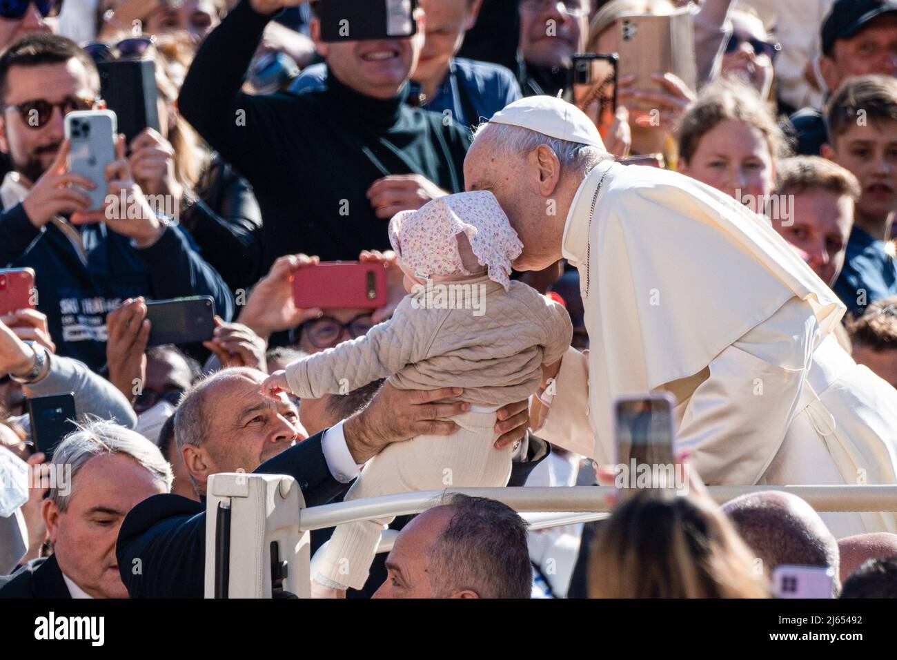 Pope Francis kisses a baby as he arrives to lead his traditional ...