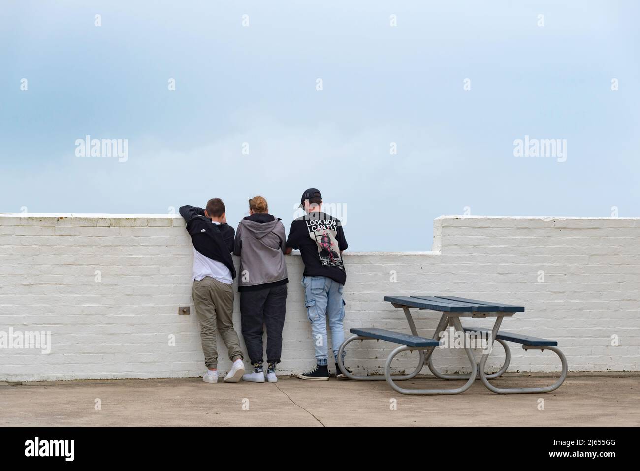Three people looking over a wall hi-res stock photography and images ...