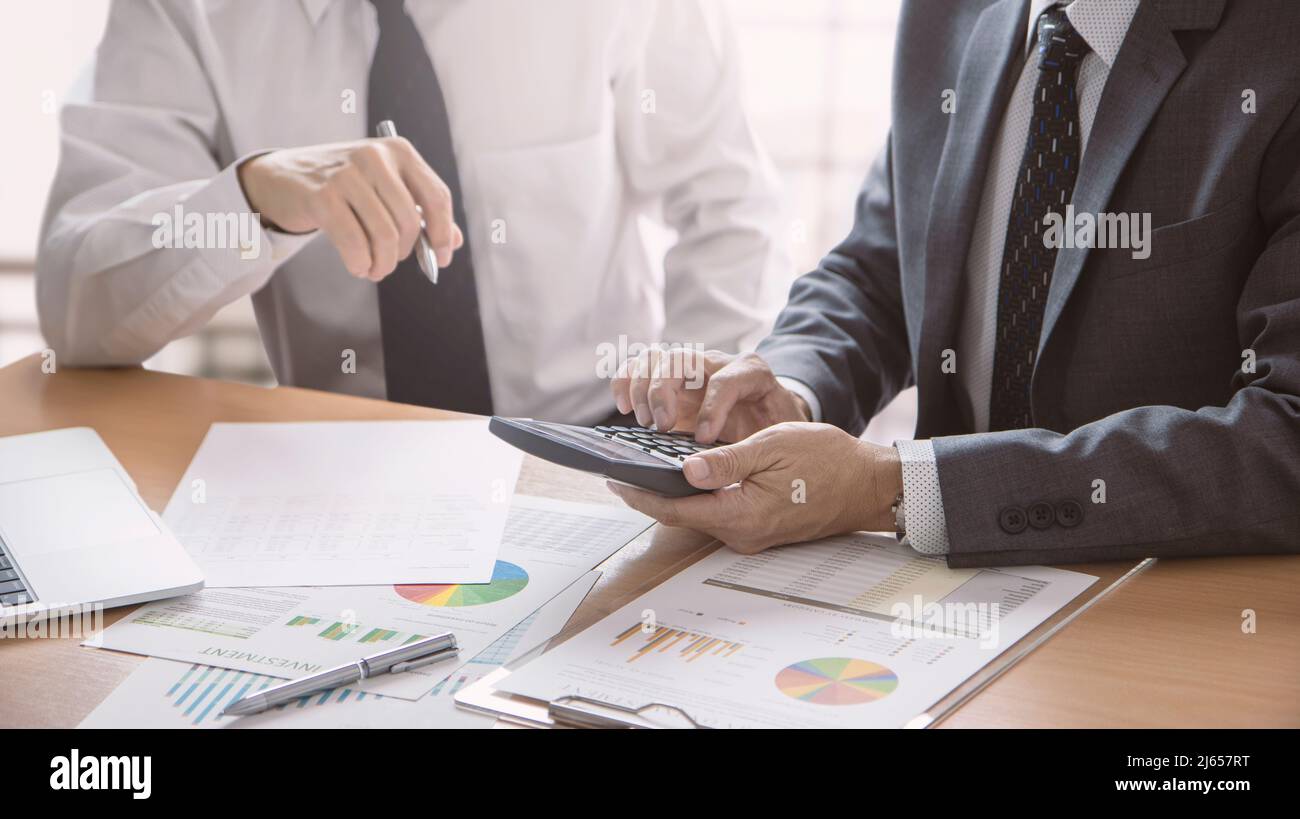Two businessmen with laptop computer reviewing financial statements for ...