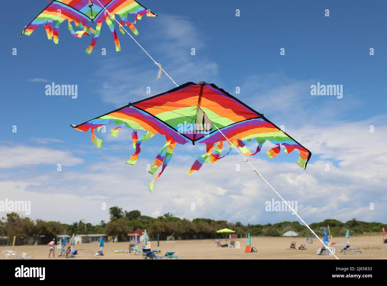 Two colorful kites on the beach during the summer holidays symbol of ...