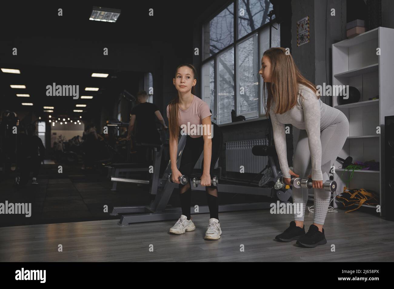 Full length shot of a teen girl and her personal trainer doing ...