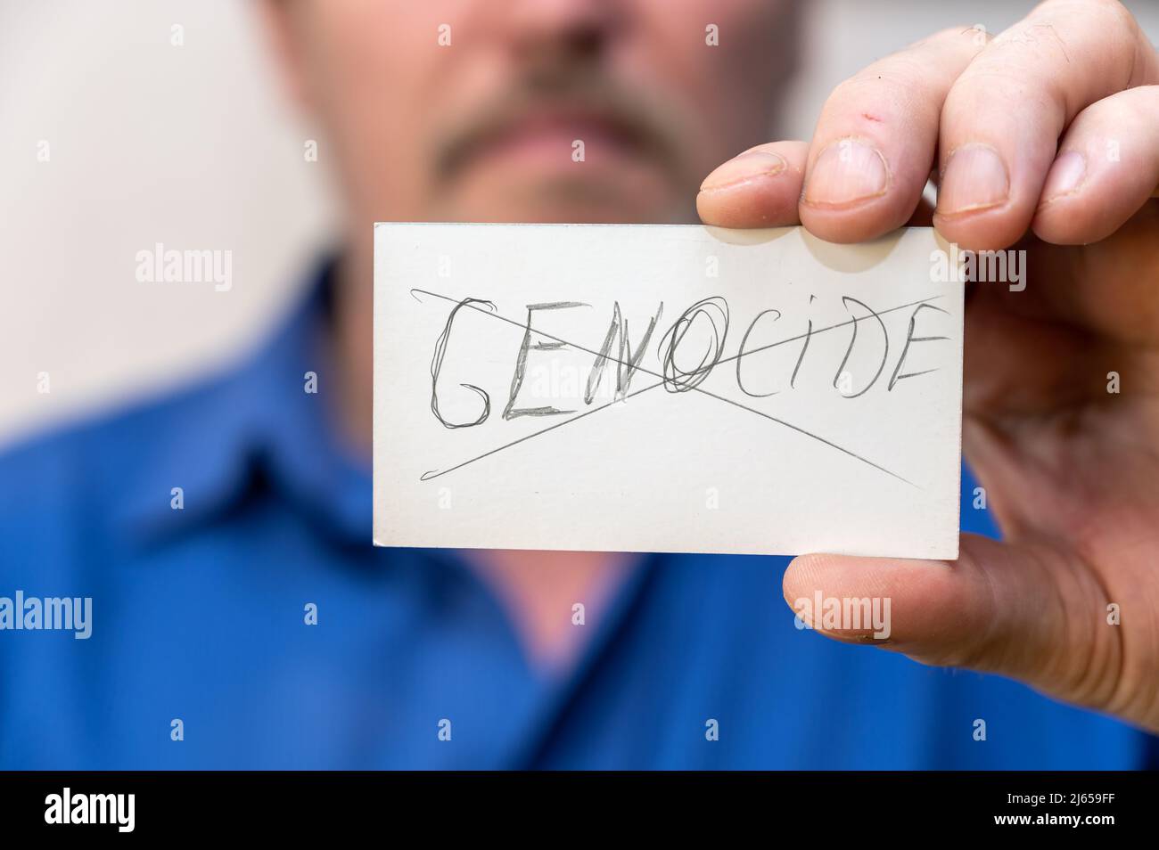 The word Genocide is crossed out. It is written in jagged gray letters ...