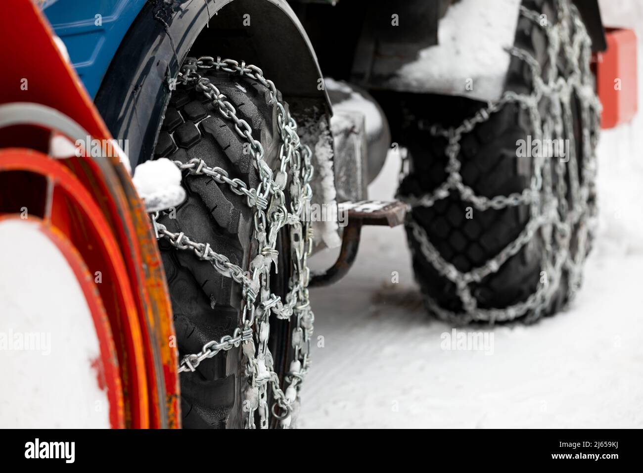 Picture of a vehicle tyre with snow chains on a frozen road Stock Photo ...