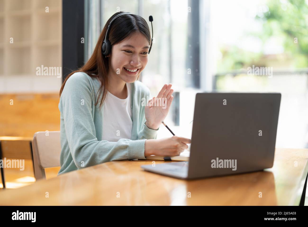 Smiling girl student wear wireless headphone study online with teacher ...
