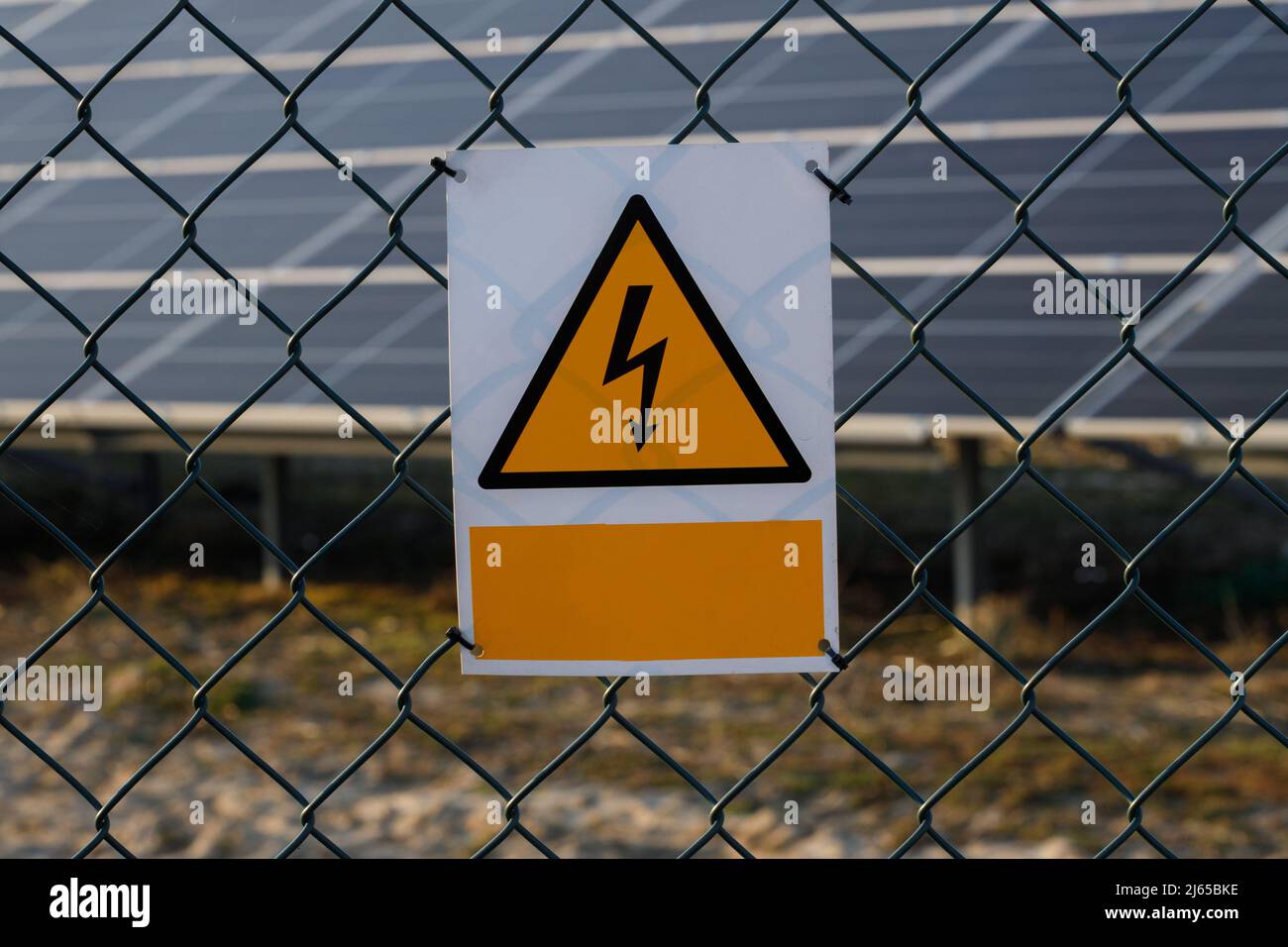 High voltage sign with solar panels in background Stock Photo - Alamy
