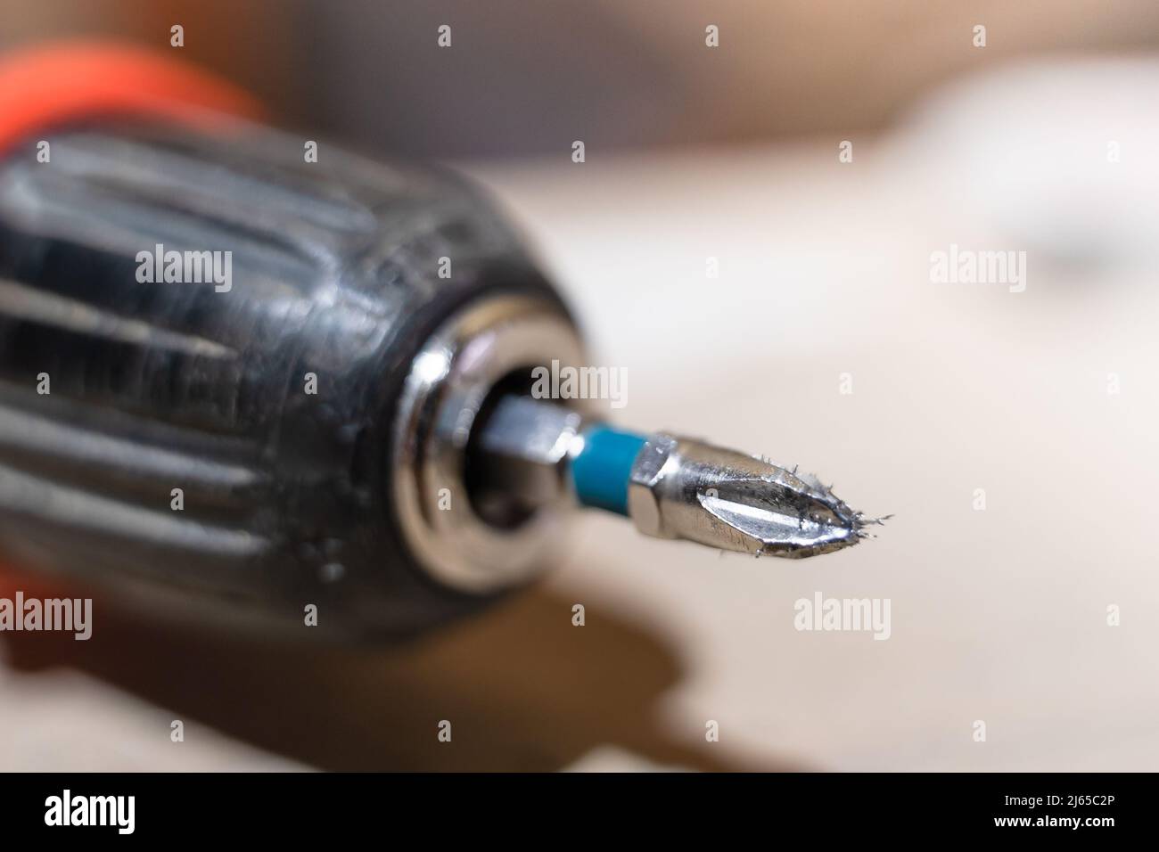 Cross bit in a screwdriver chuck with magnetic iron shavings close-up ...