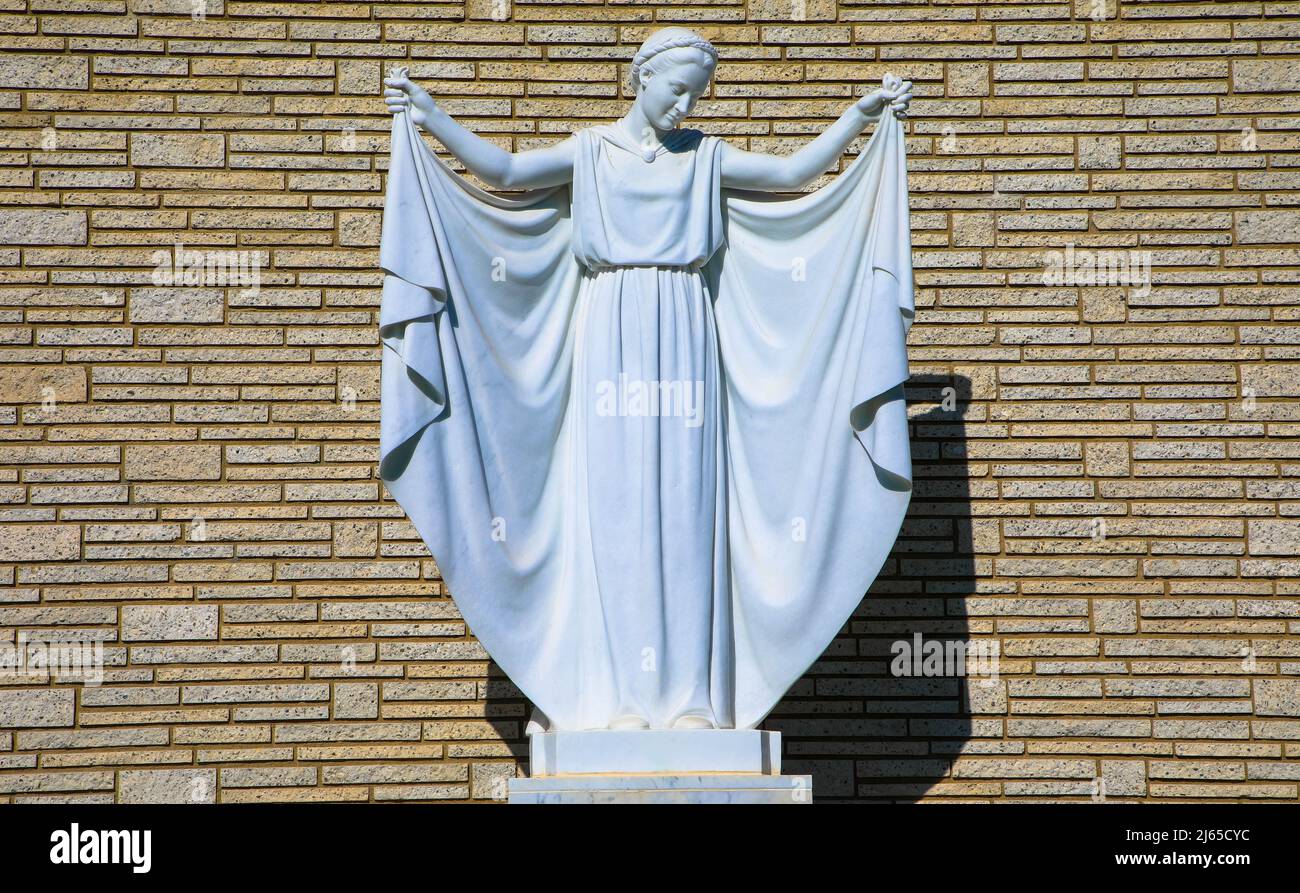 Magnificent plaster statue of a woman against brick wall. Symbol of ...