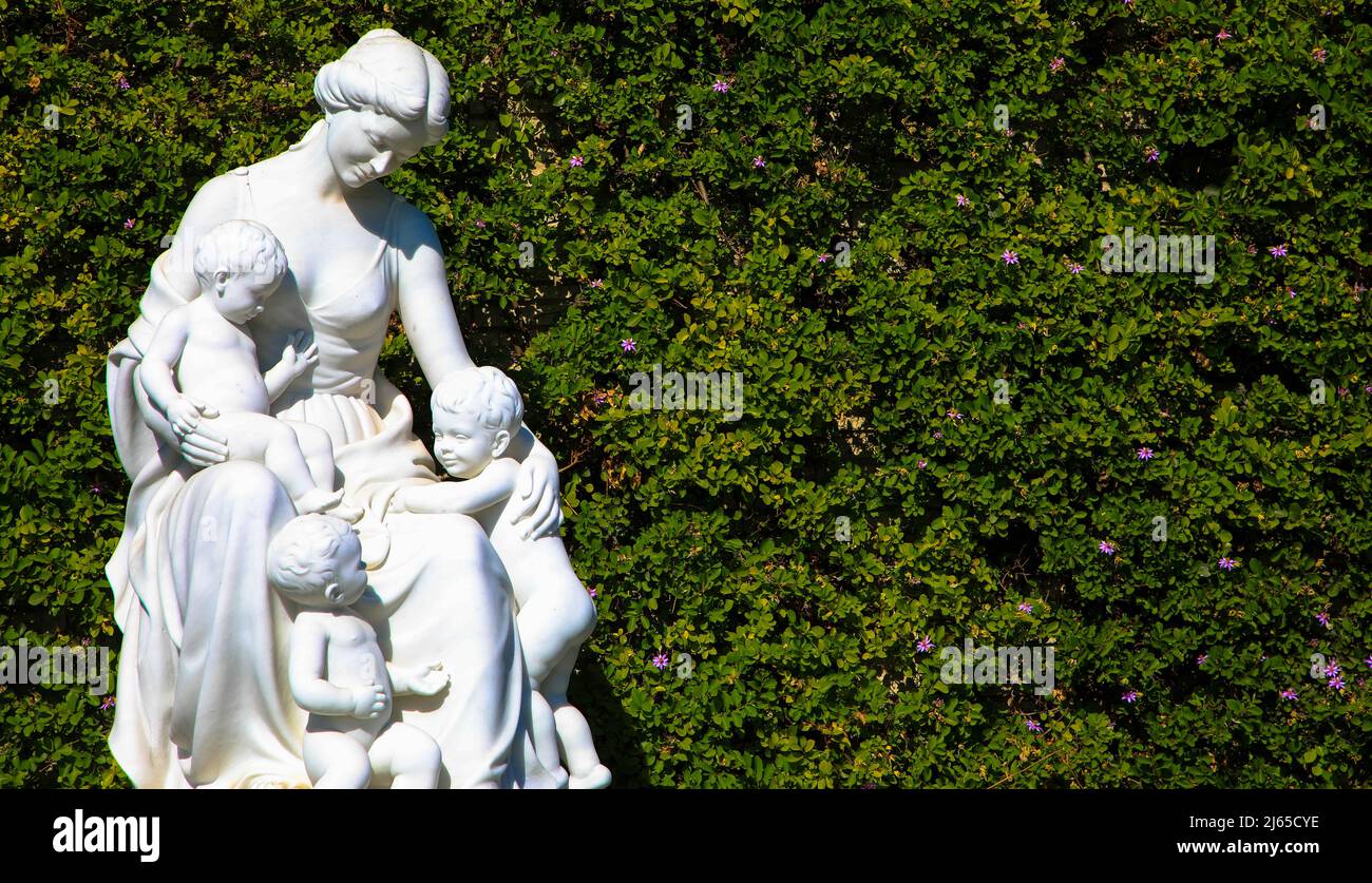 Magnificent plaster statue of a woman against green Background. Symbol ...