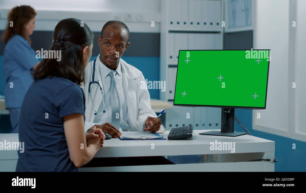 Male doctor and woman using green screen on computer in medical cabinet ...