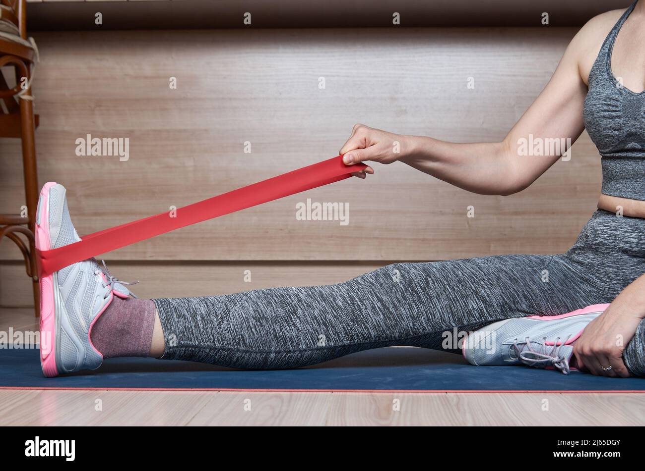 Resistance band exercise at home. Woman doing pilates workout using ...