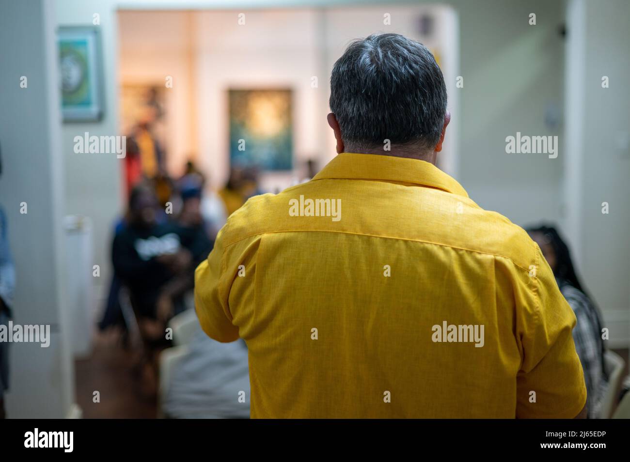 Man addressing people indoors shot from behind Stock Photo - Alamy
