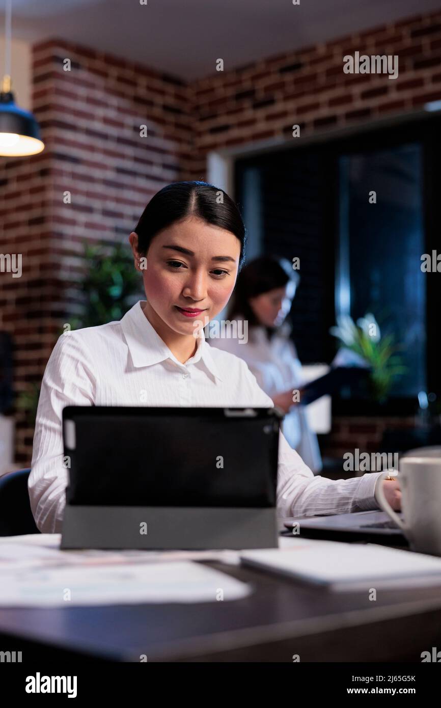 Executive manager working on electronic touchscreen device while ...