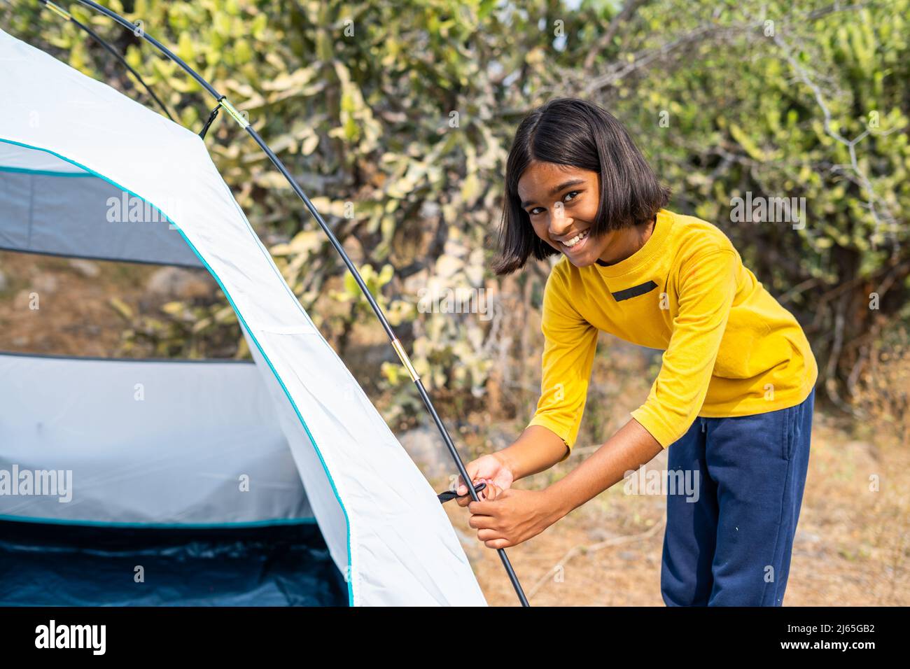 happy smiling Teenager Girl kid making camping tent at hill during ...