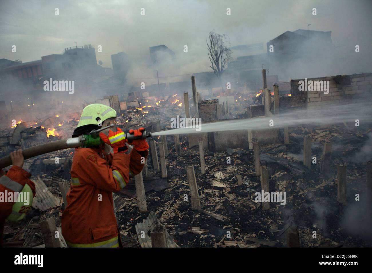 Firefighters performing the cooling phase after a fire accident burned ...