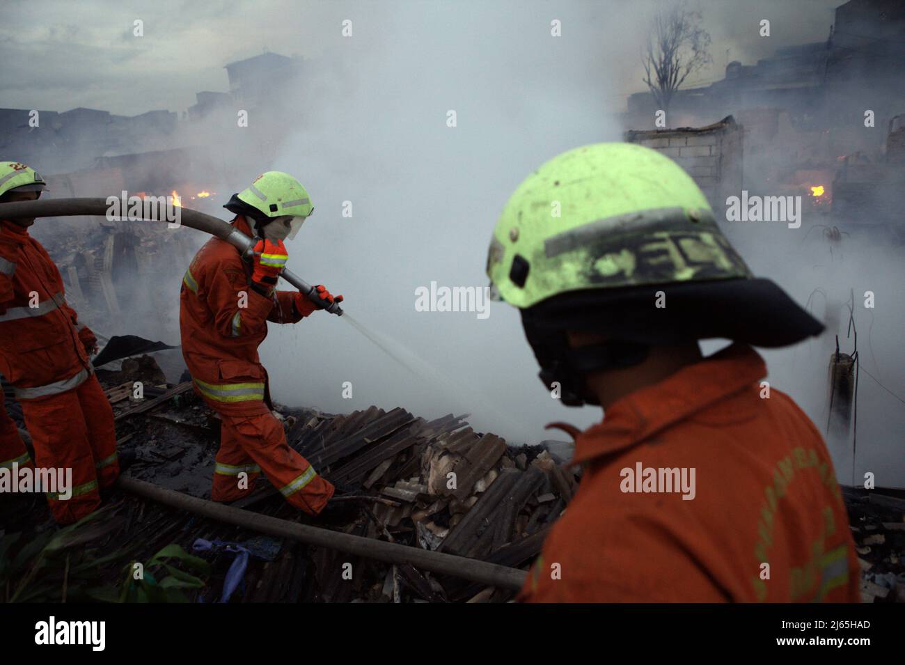 Firefighters performing the cooling phase after a fire accident burned ...