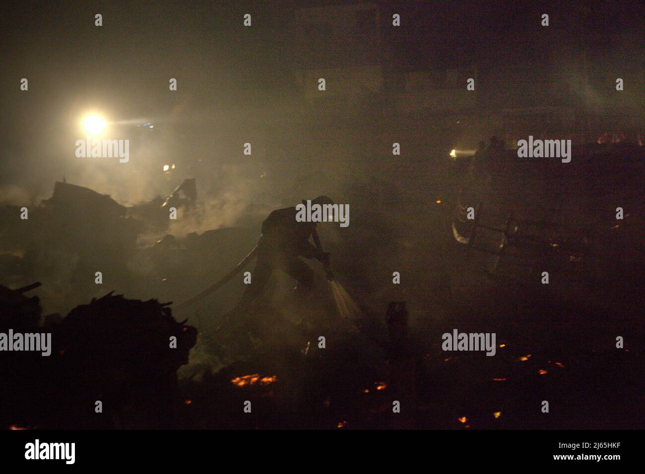 Firefighters performing the cooling phase after a fire accident burned ...