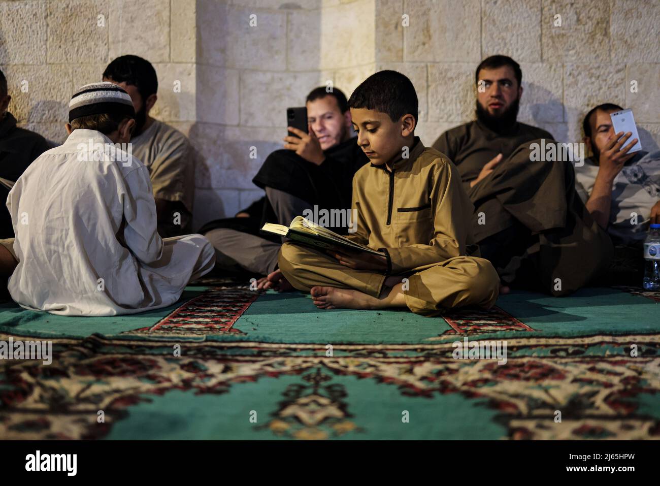 Idlib, Syria. 27th Apr, 2022. A young Syrian Muslim reads the Holy ...
