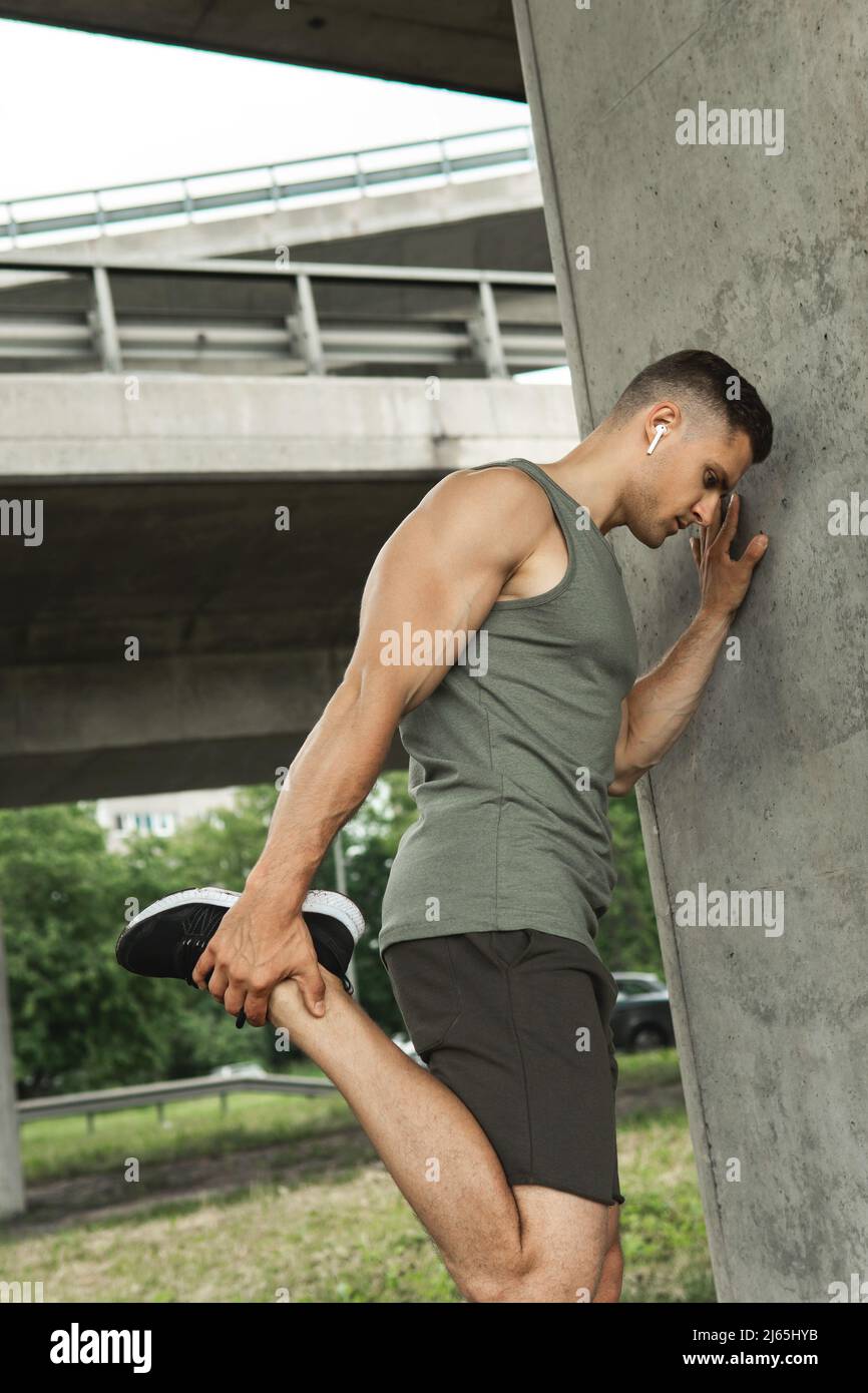 Muscular man warming up before his outdoor fitness workout Stock Photo ...