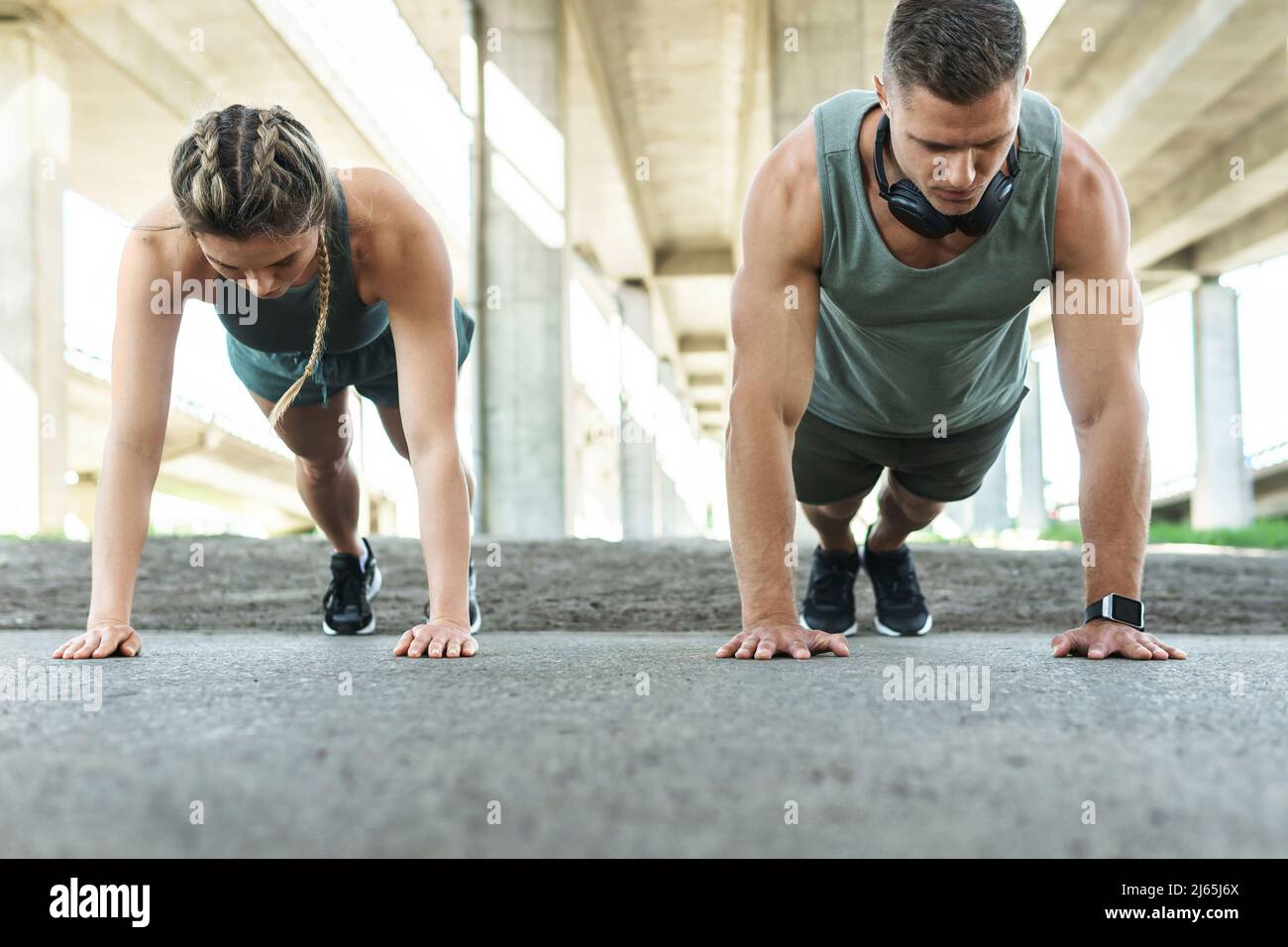Athletic couple and fitness training outdoors. Man and woman doing push ...
