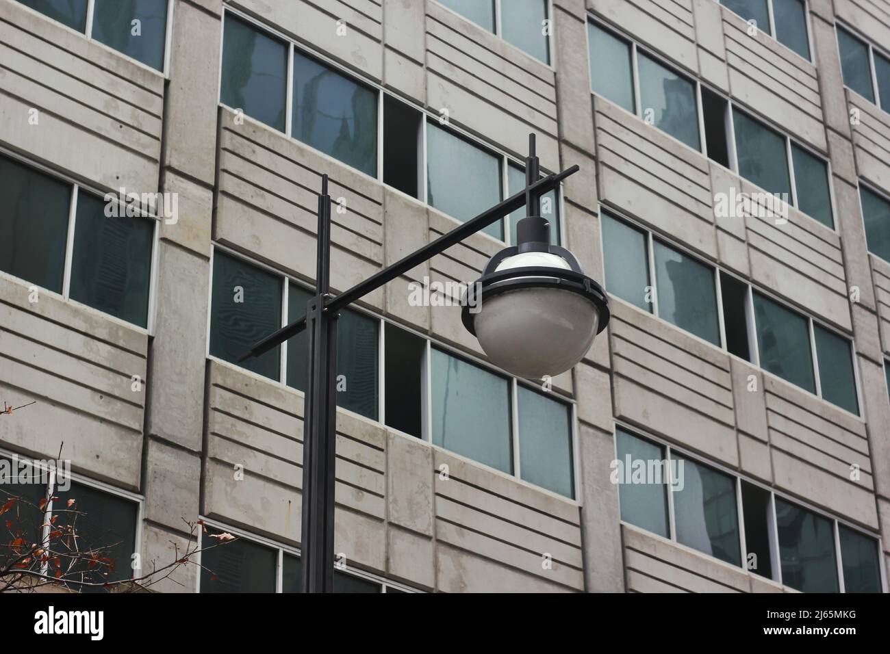 A modern contemporary street lamp standing on the street in front of a ...