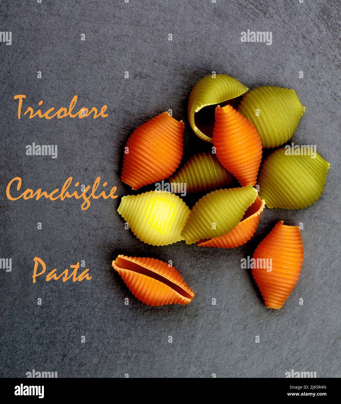 Arrangement of Raw Tricolore Conchiglie Pasta with Inscription closeup ...