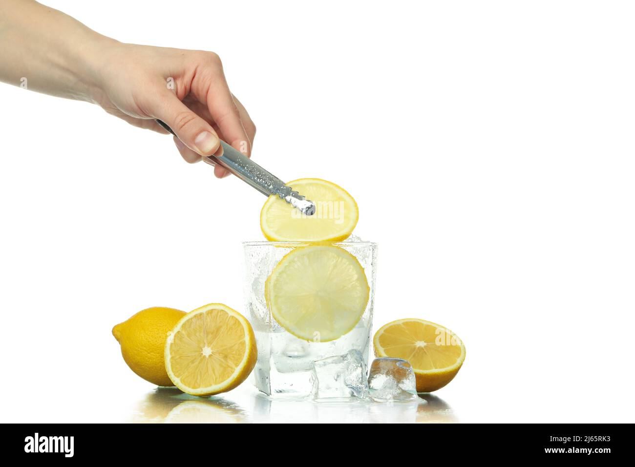 Female hand puts lemon slice in glass, isolated on white background ...