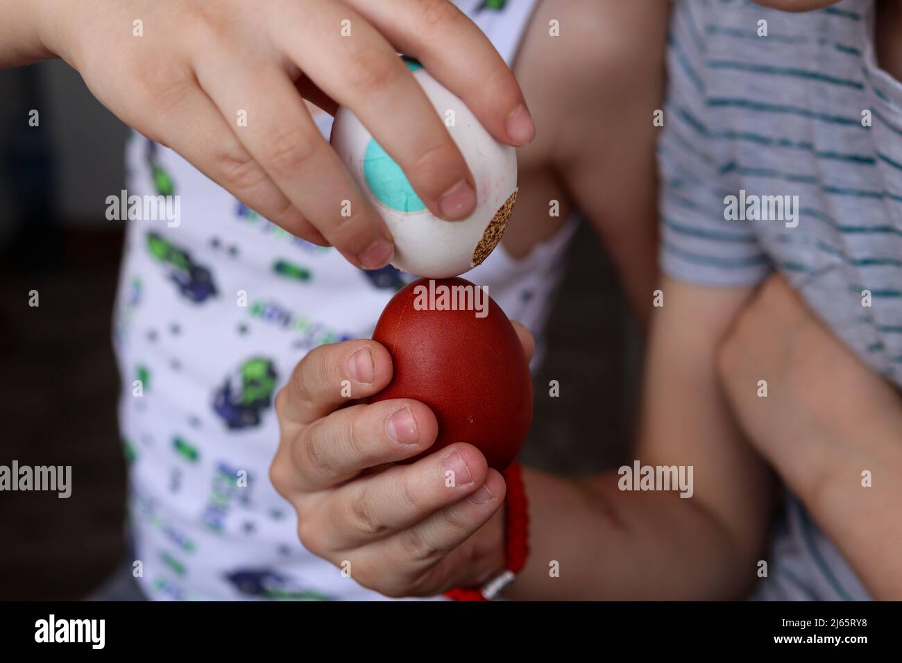 Childrens hands knocking Easter eggs outdoor. Traditional egg fight ...