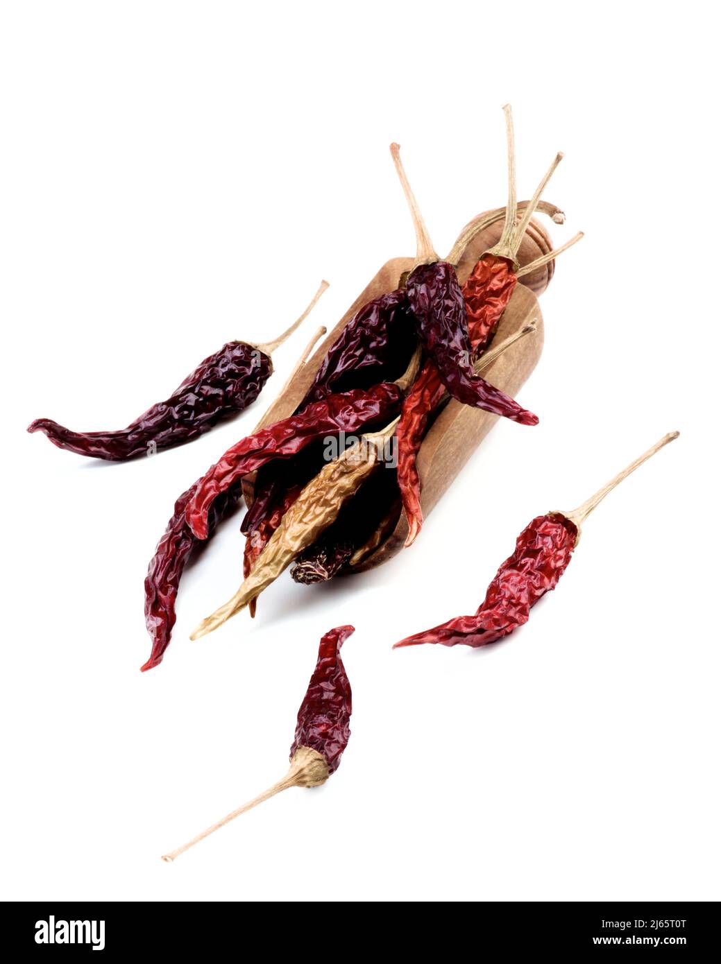Various Dried Chili Peppers in Wooden Scoop closeup on White background ...