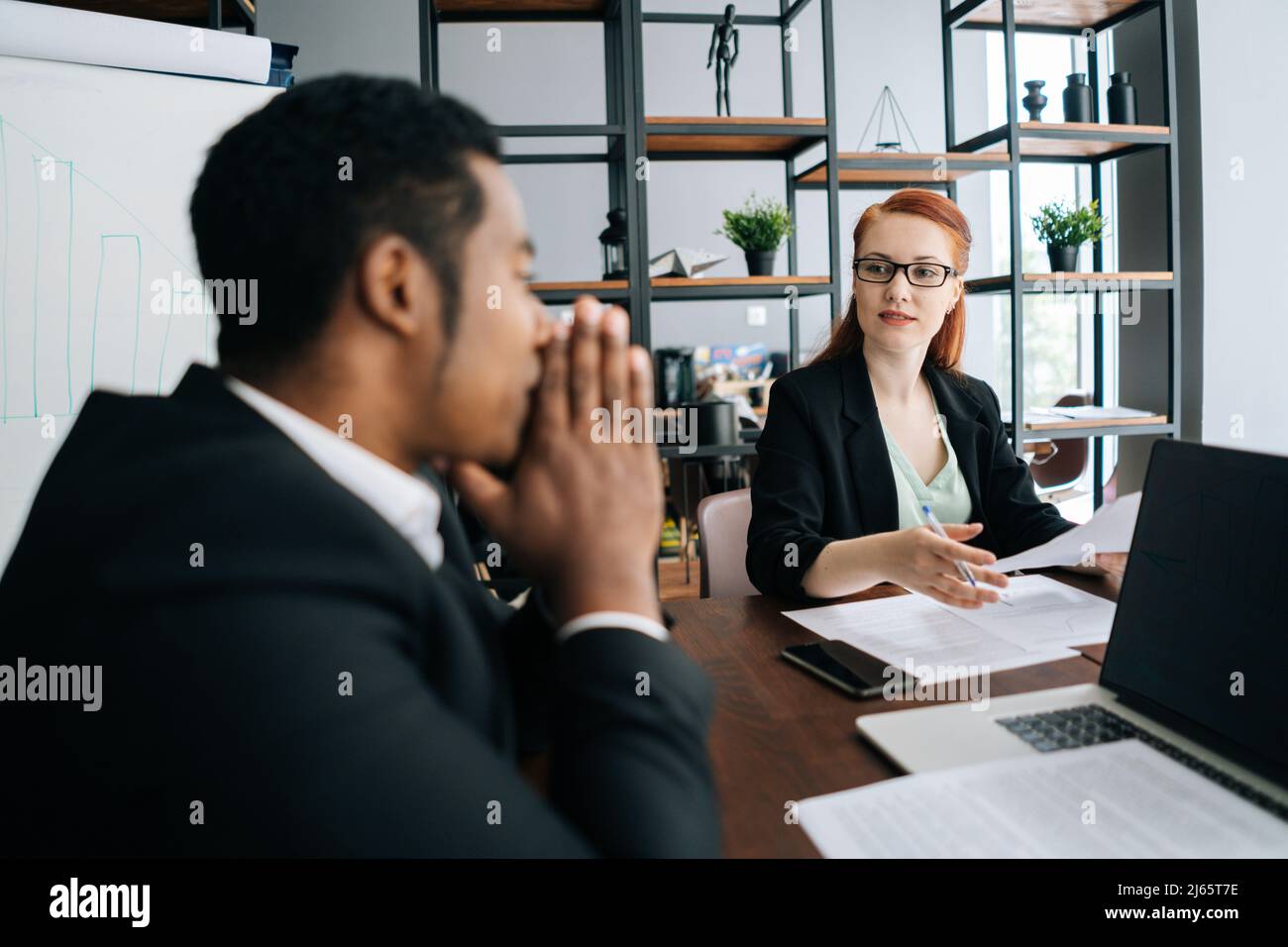 African-American businessman listening female team leader taking part ...