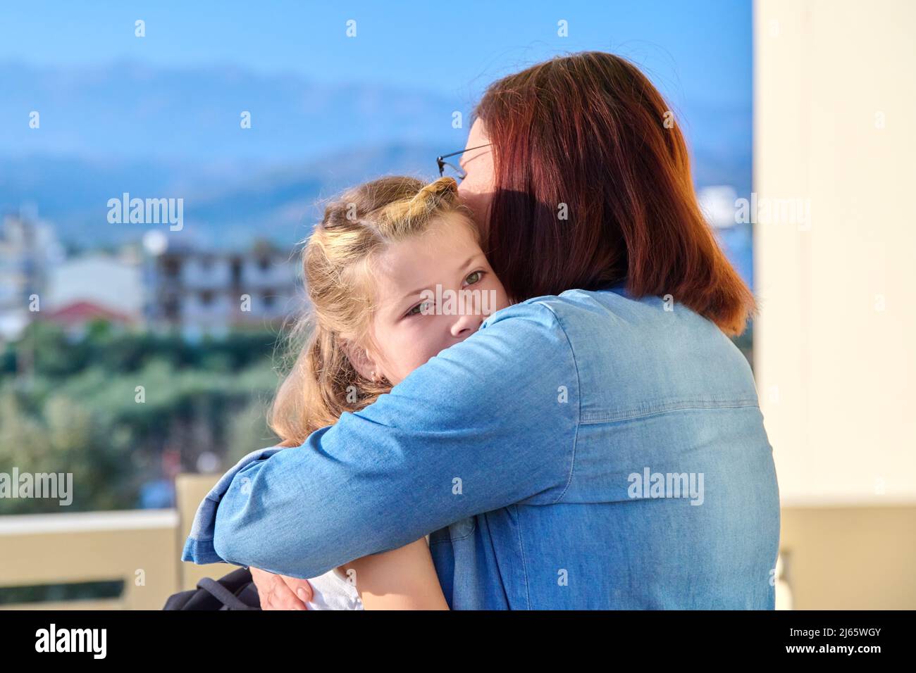 Mom hugging her preteen daughter on the porch of the house Stock Photo - Alamy