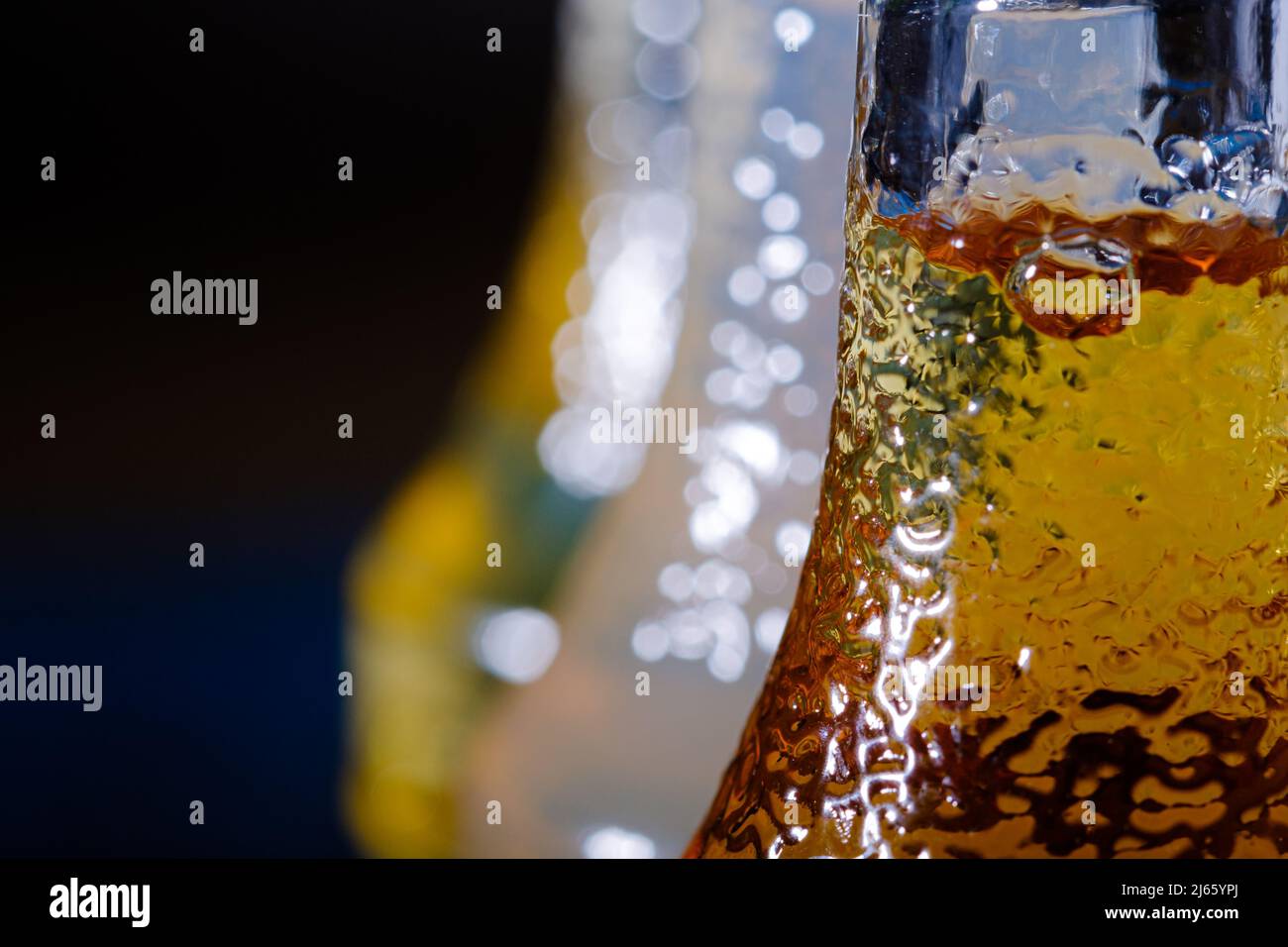 glass bottle with alcoholic liquor inside on different colours close up ...