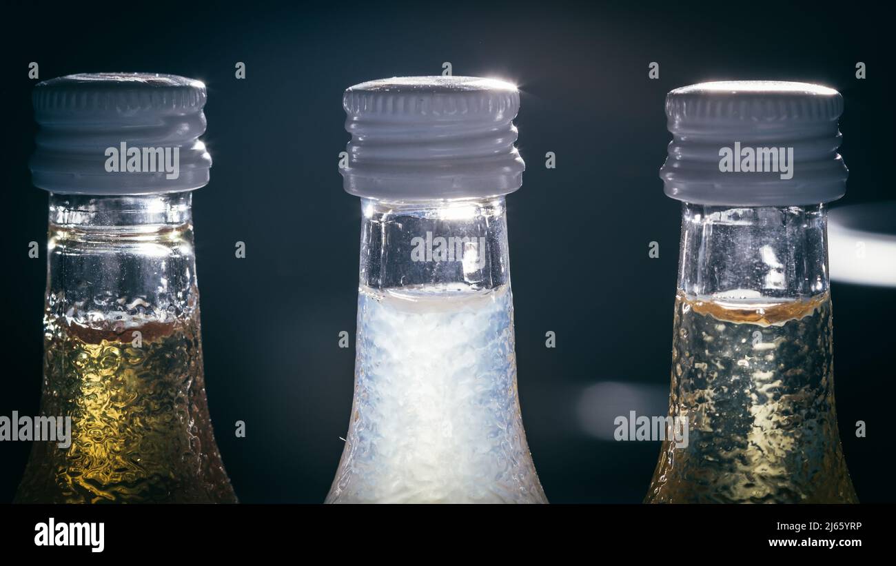 Textured bottle glass close up still with many colours with white taps ...