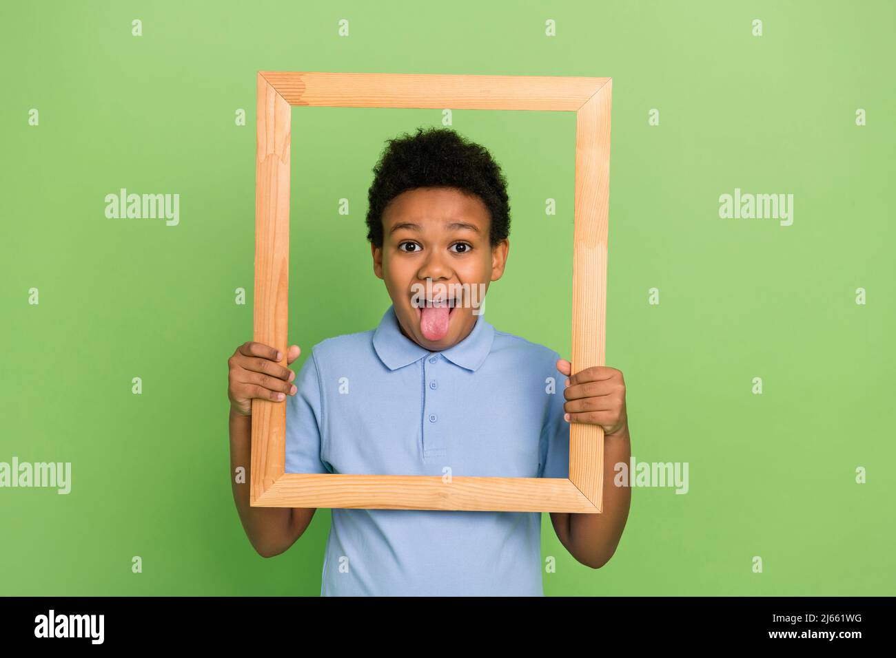 Portrait of handsome cheerful funny foolish pre-teen boy holding photo ...